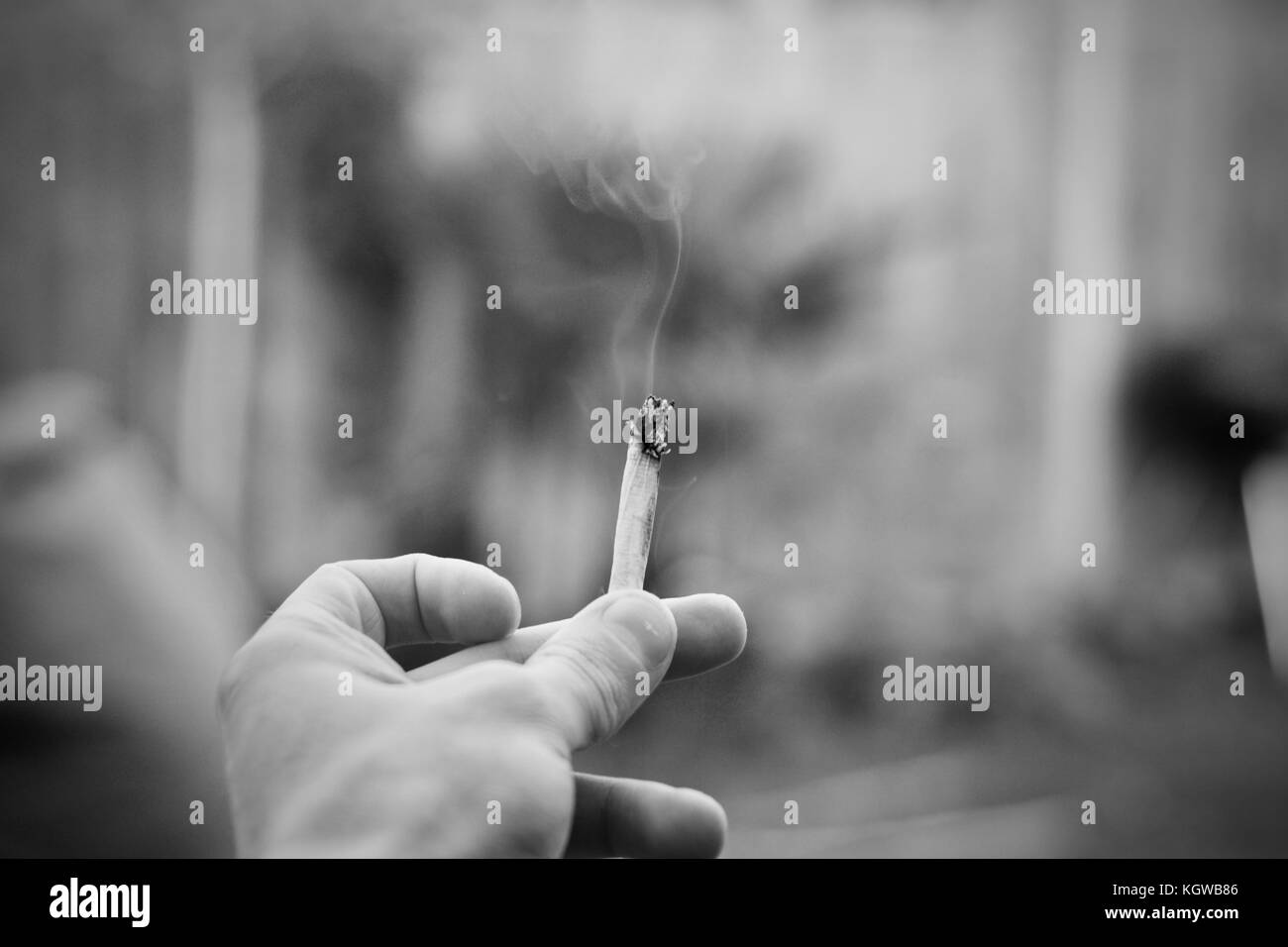 Small spliff in man hand. Marijuana smoking concept Stock Photo - Alamy