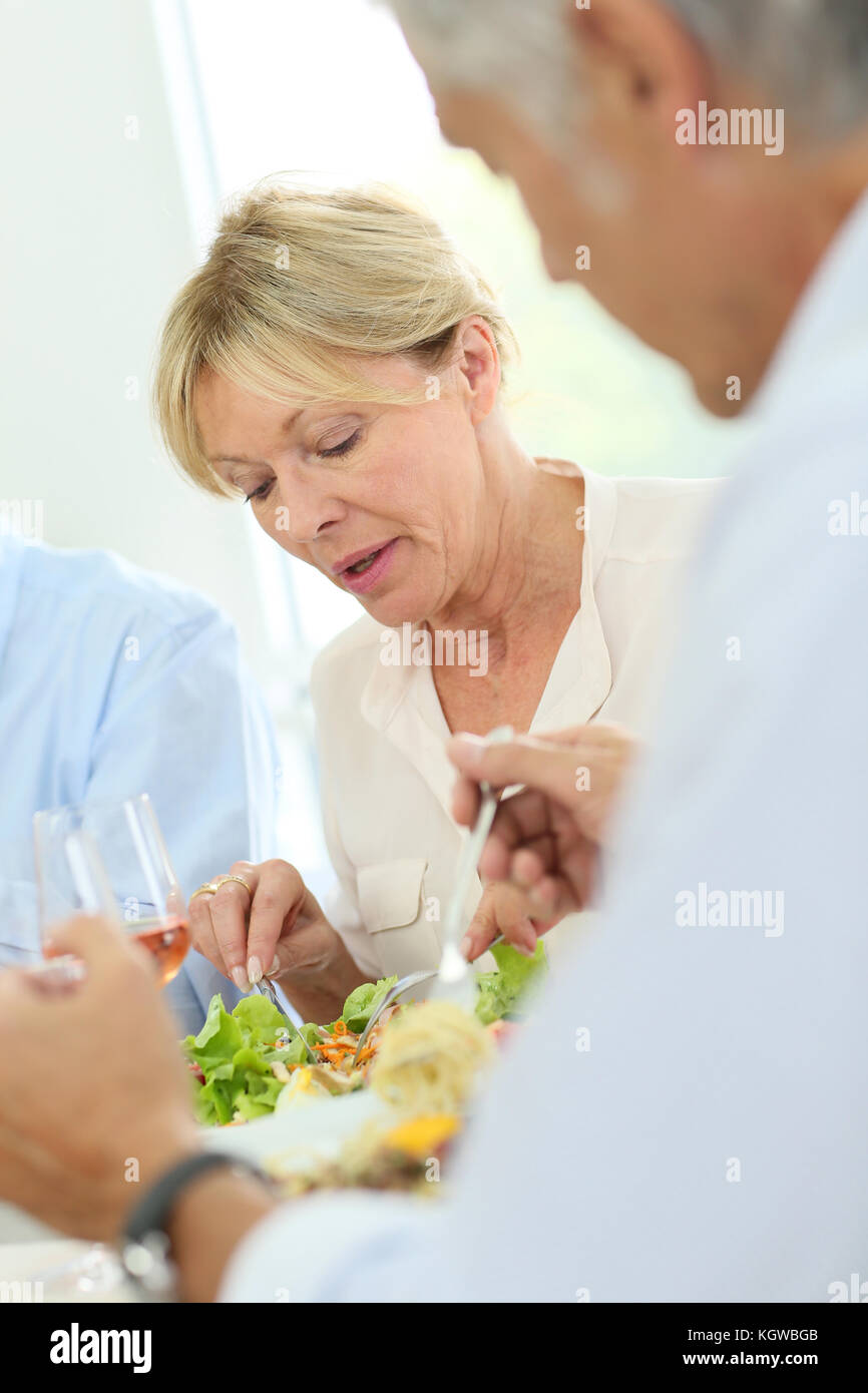 Portrait of senior woman sharing lunch with friends Stock Photo - Alamy