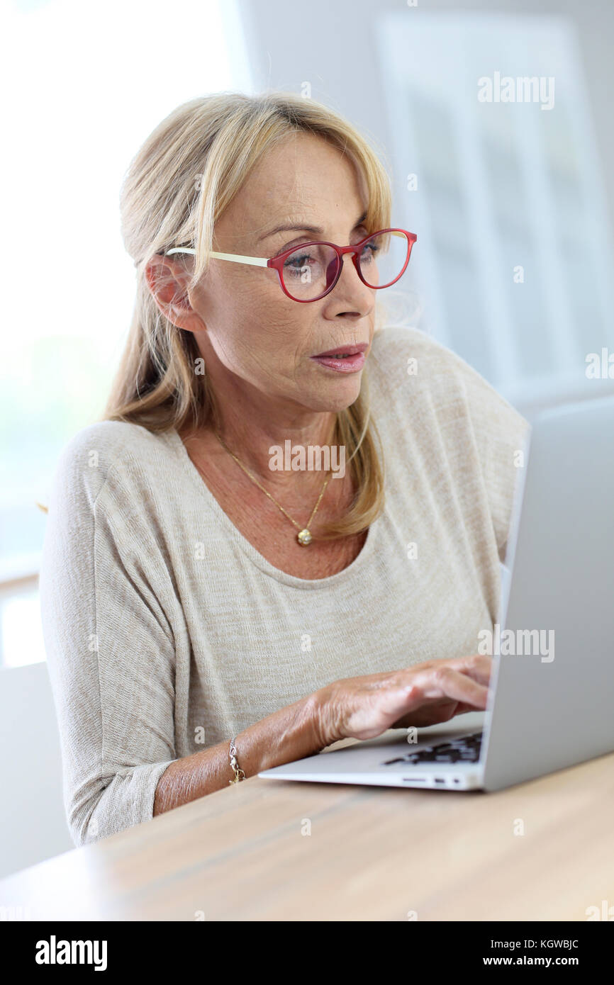 Elderly woman with eyeglasses using laptop computer Stock Photo - Alamy