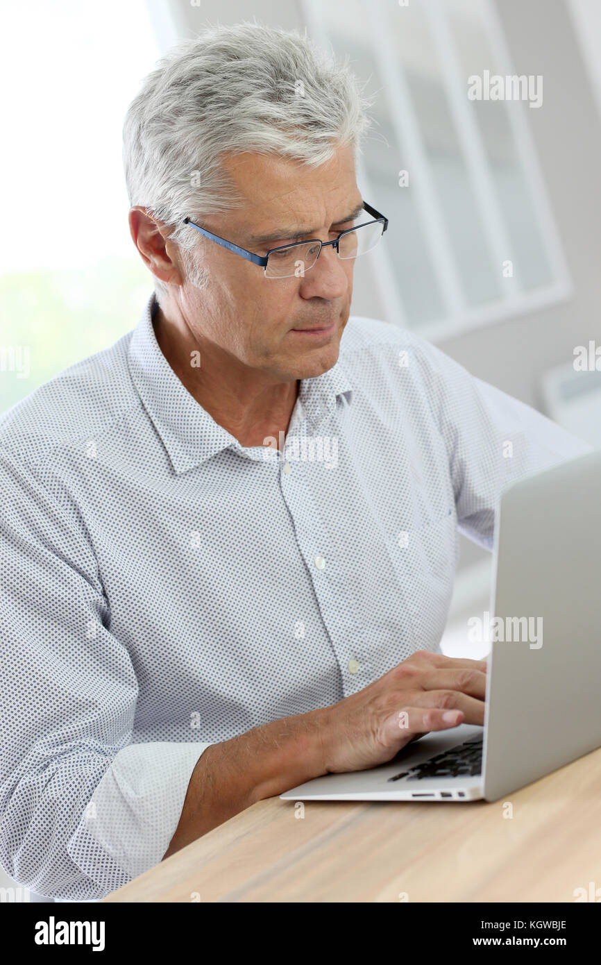 Senior man with eyeglasses using laptop computer Stock Photo - Alamy