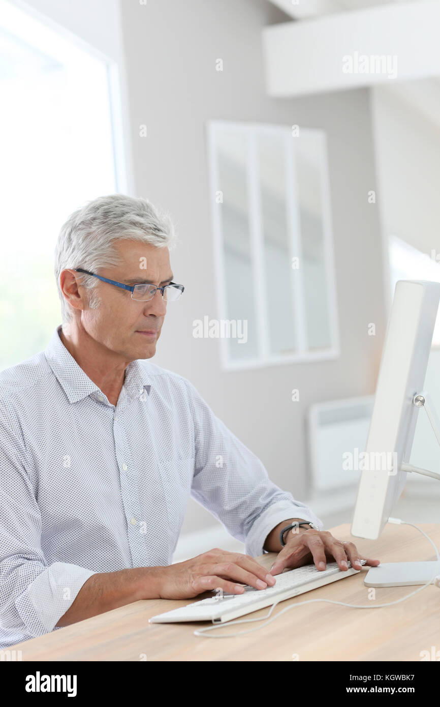 Senior man connected on desktop computer Stock Photo - Alamy