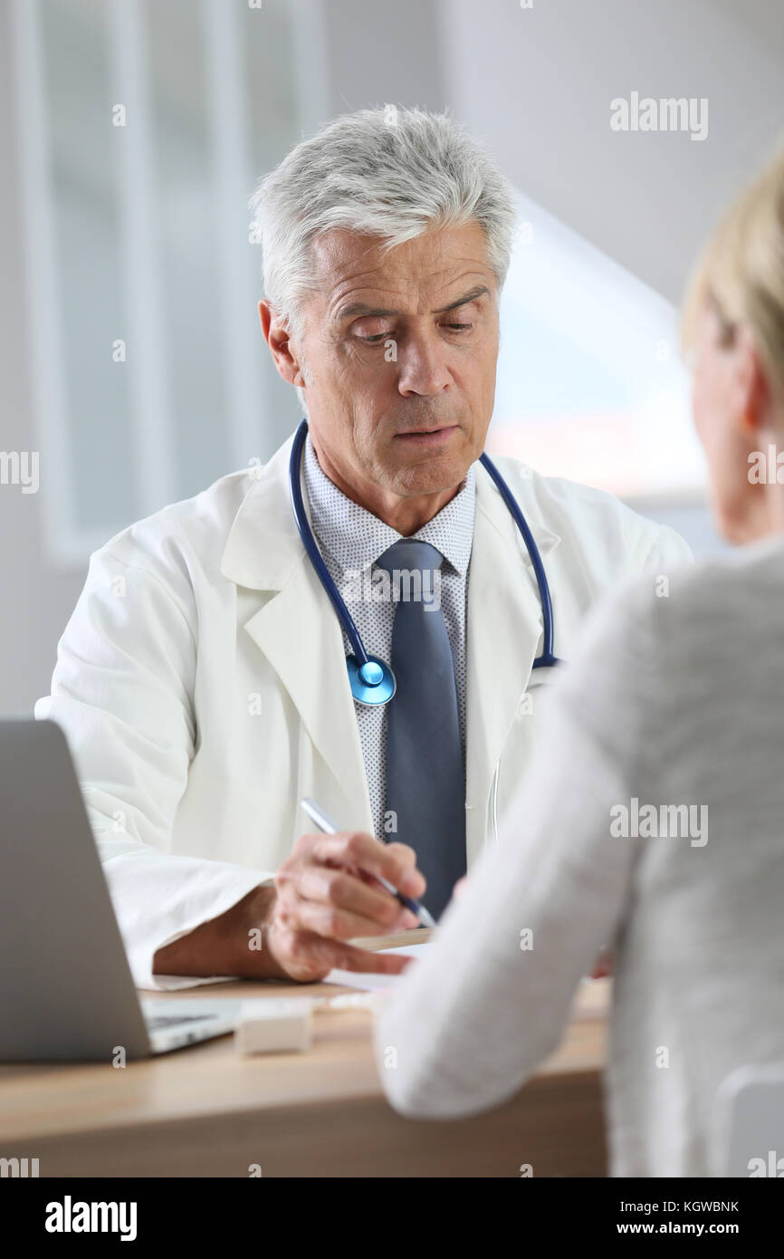 Doctor having consultation with patient in office Stock Photo - Alamy