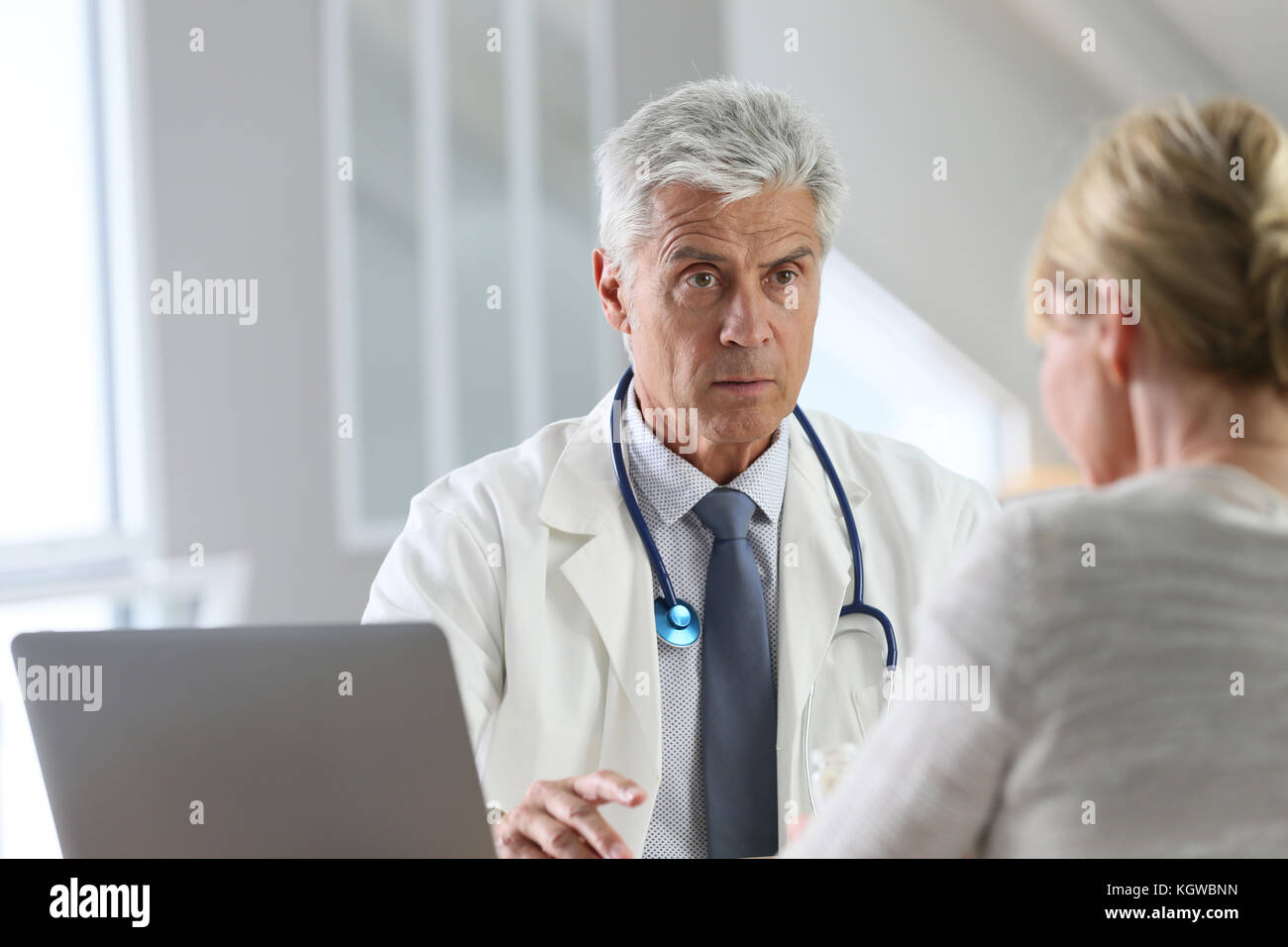 Doctor having consultation with patient in office Stock Photo - Alamy