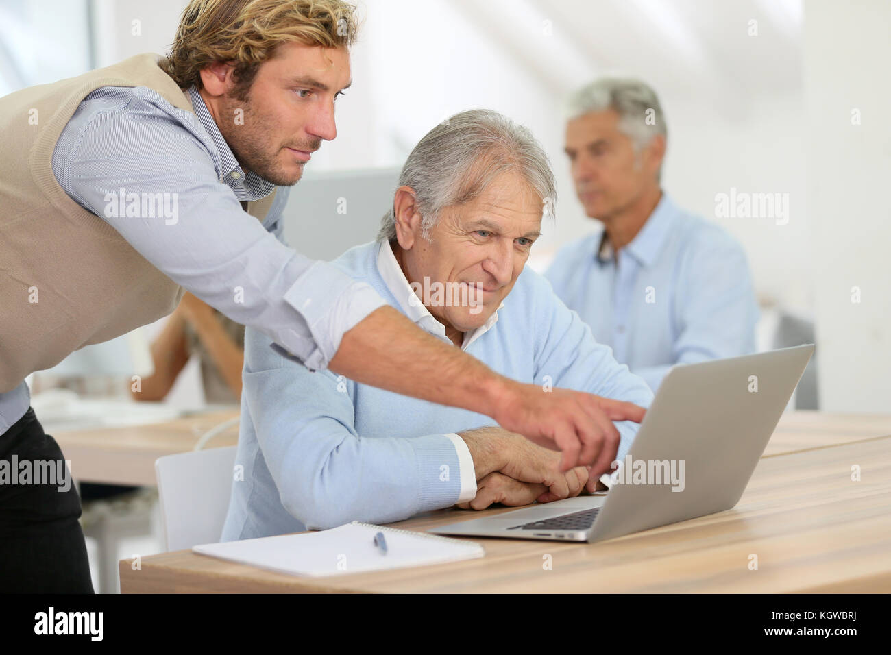 Senior man attending business class with trainer Stock Photo - Alamy