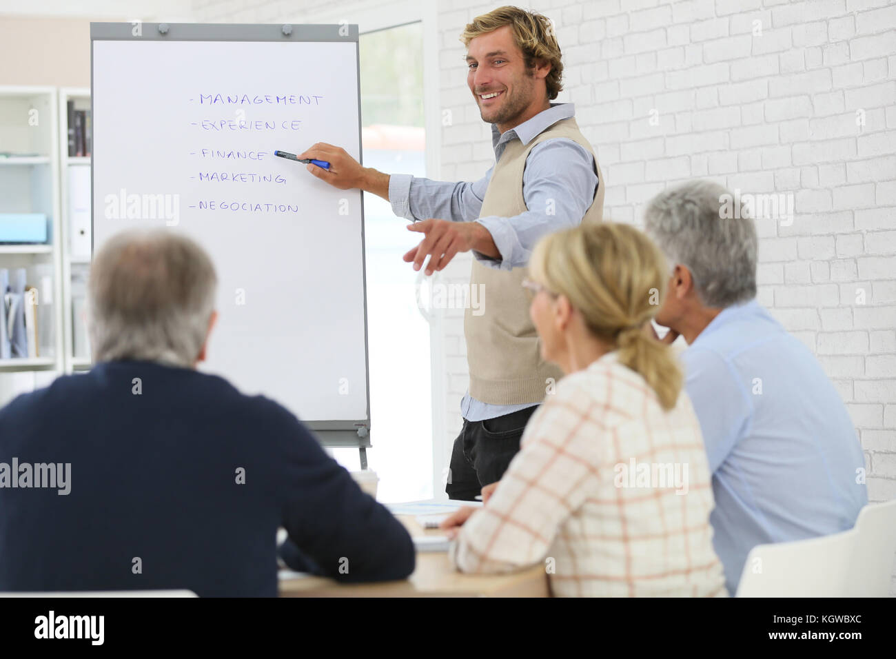 Business instructor leading meeting with senior training group Stock ...