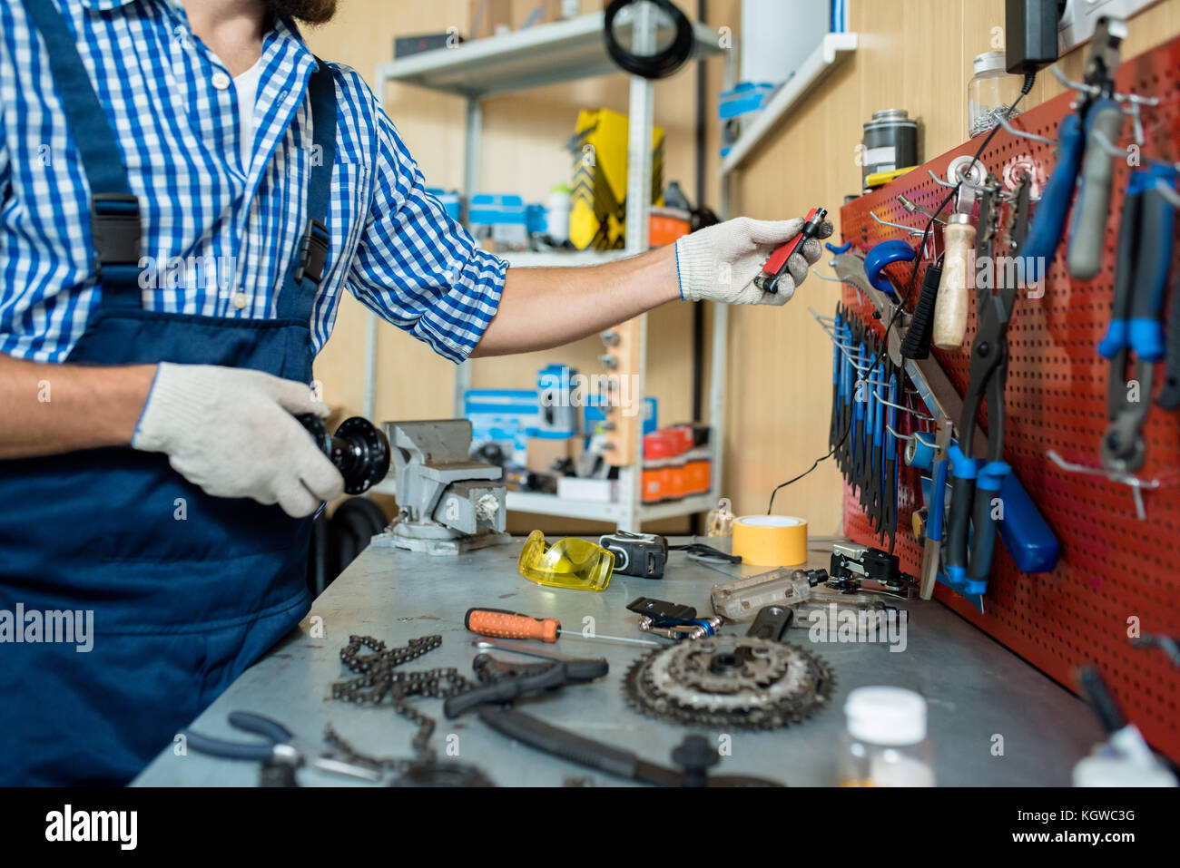 Repairman taking one of tools from toolkit panel on the wall Stock ...