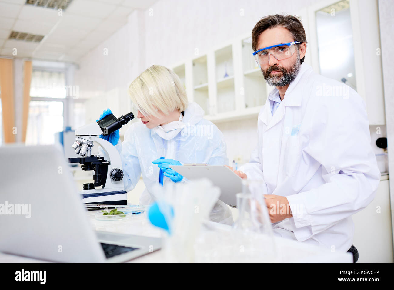 Professional chemists carrying out investigation of new substances and ...