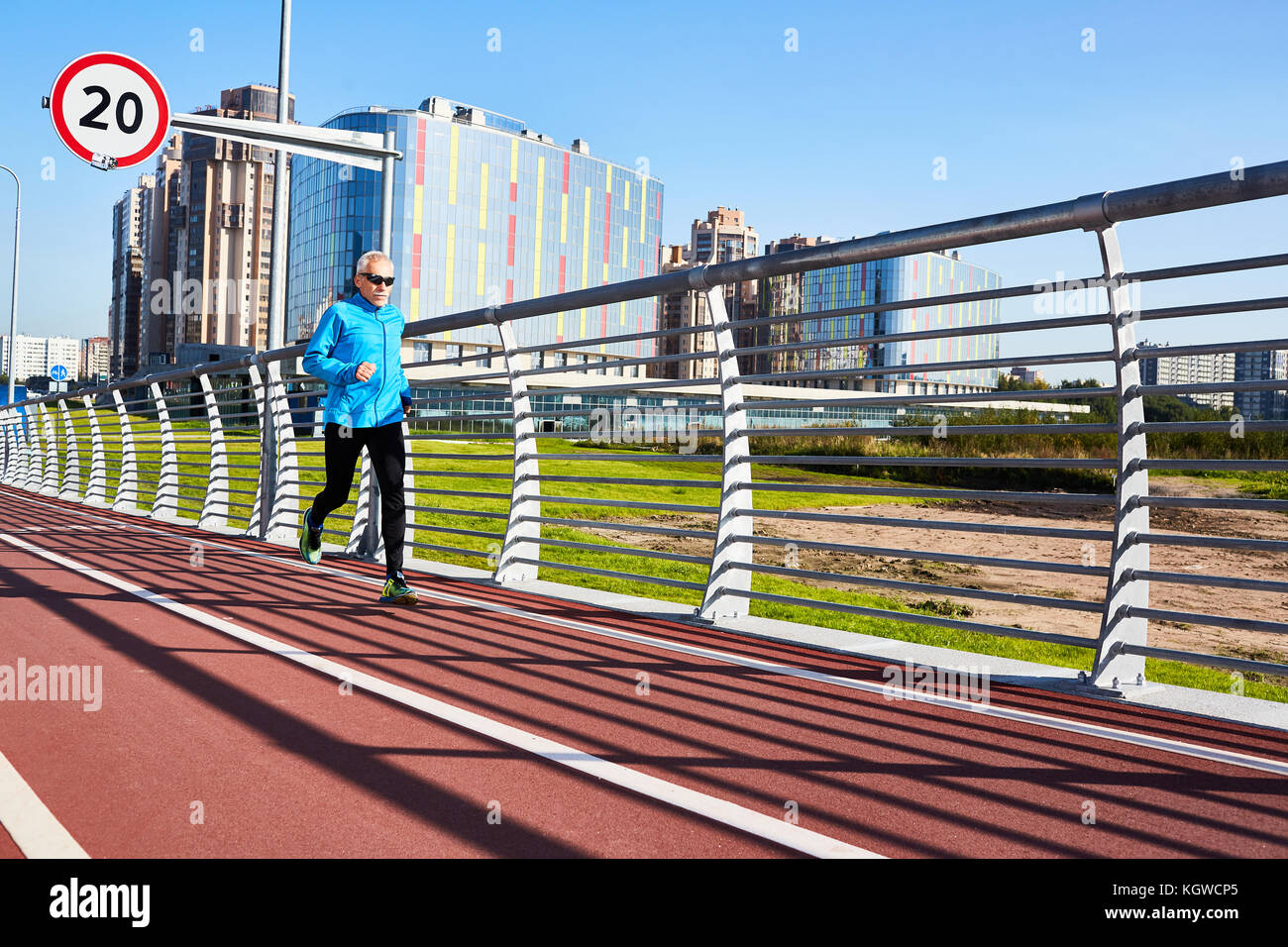 Active retired man in sportswear running down racetrack on stadium ...