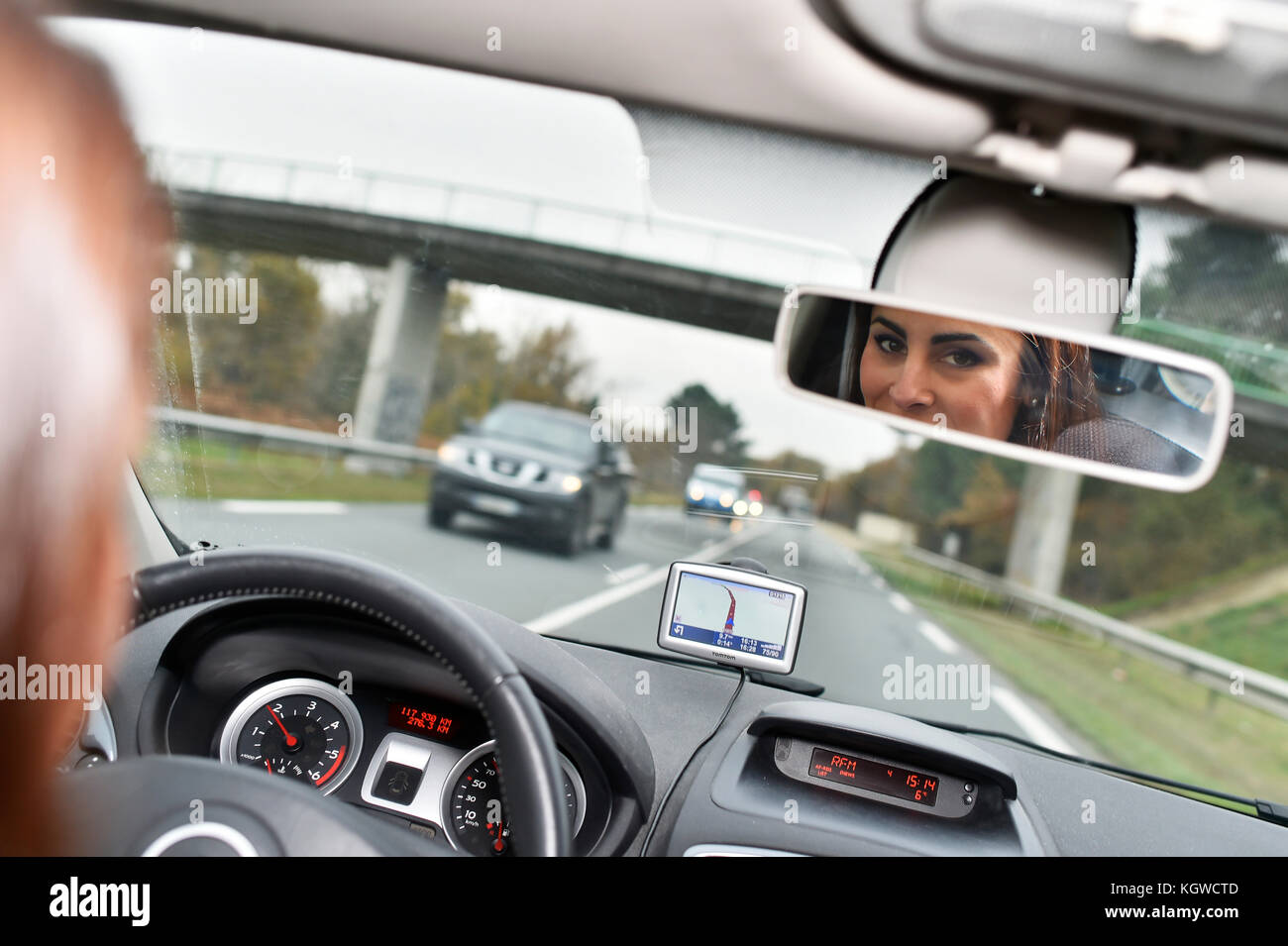 Woman in car binnacle looking at rear view mirror Stock Photo - Alamy
