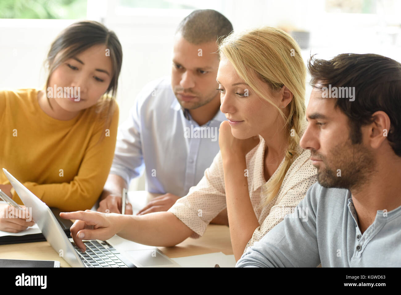 Business workgroup interacting in office Stock Photo - Alamy
