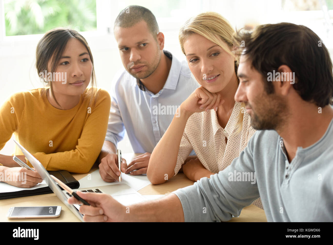 Business workgroup interacting in office Stock Photo - Alamy