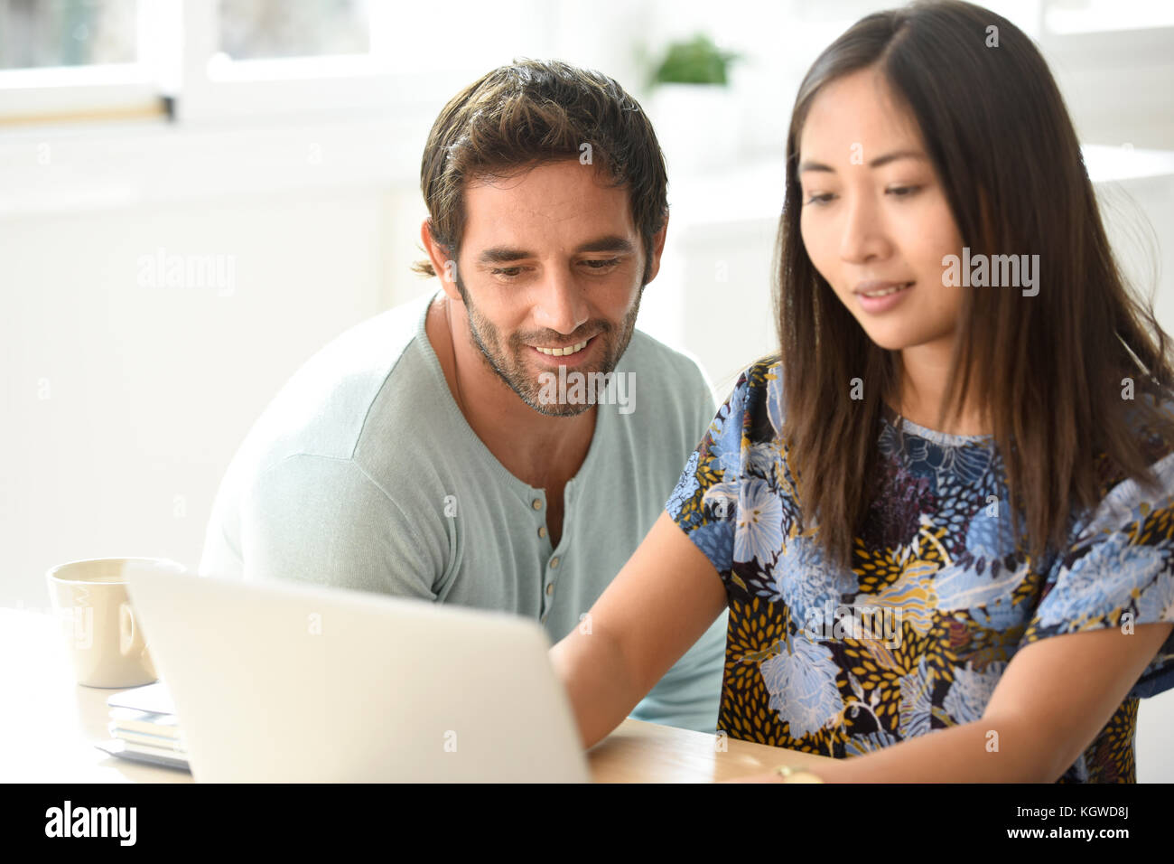 Workmates in office working on laptop Stock Photo - Alamy
