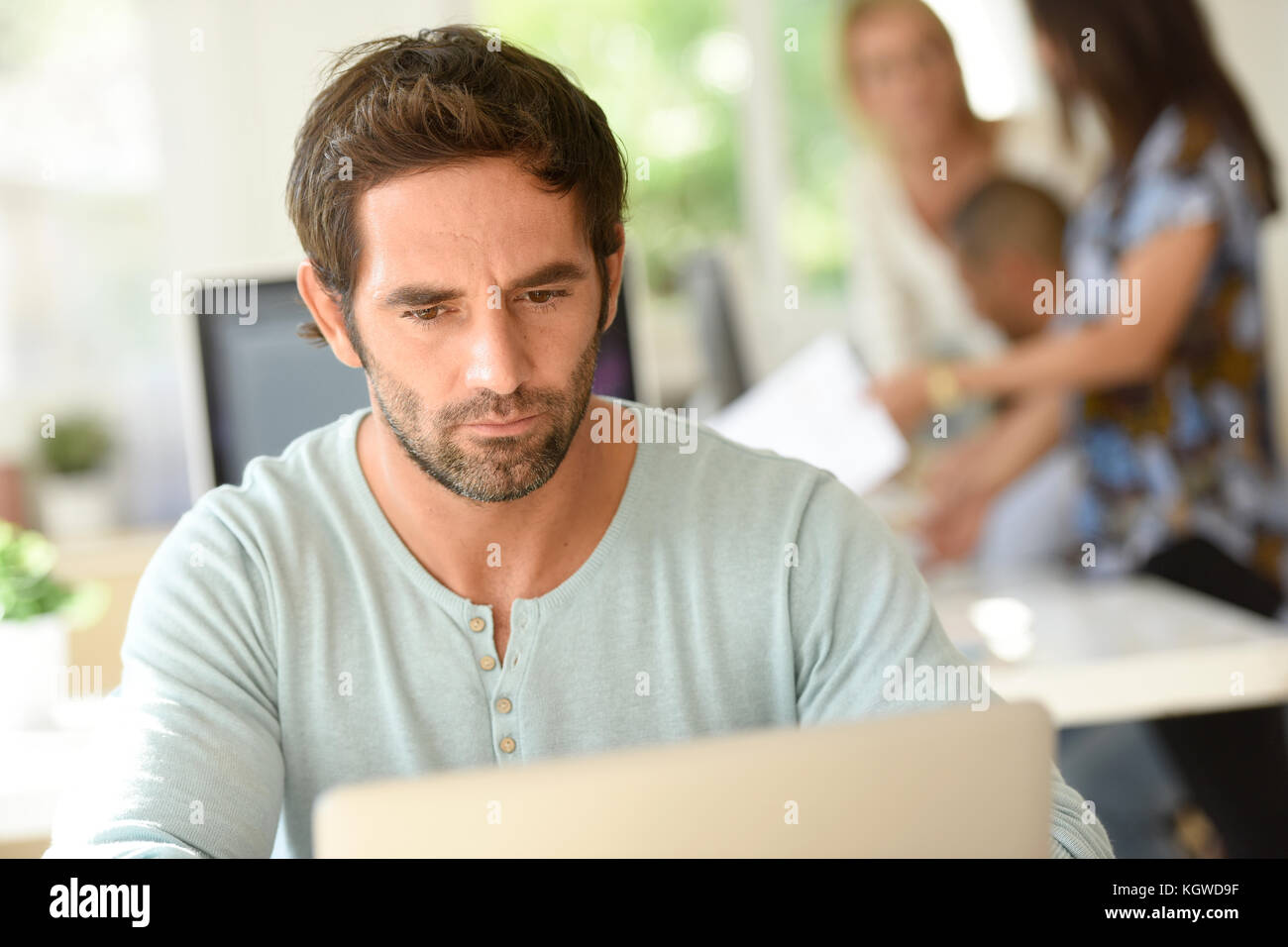 Man in office working on laptop Stock Photo - Alamy