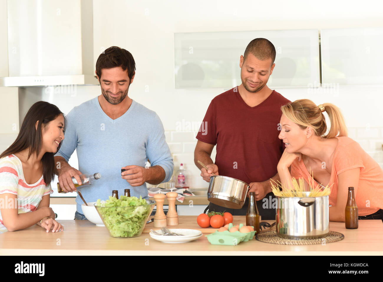 Friends having fun cooking meal together Stock Photo - Alamy