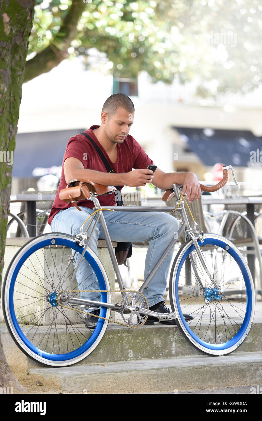 Man with bicycle sitting on park bench Stock Photo - Alamy