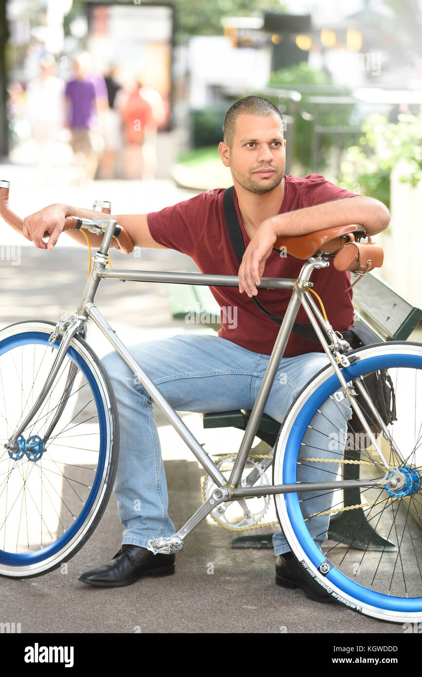 Man with bicycle sitting on park bench Stock Photo - Alamy
