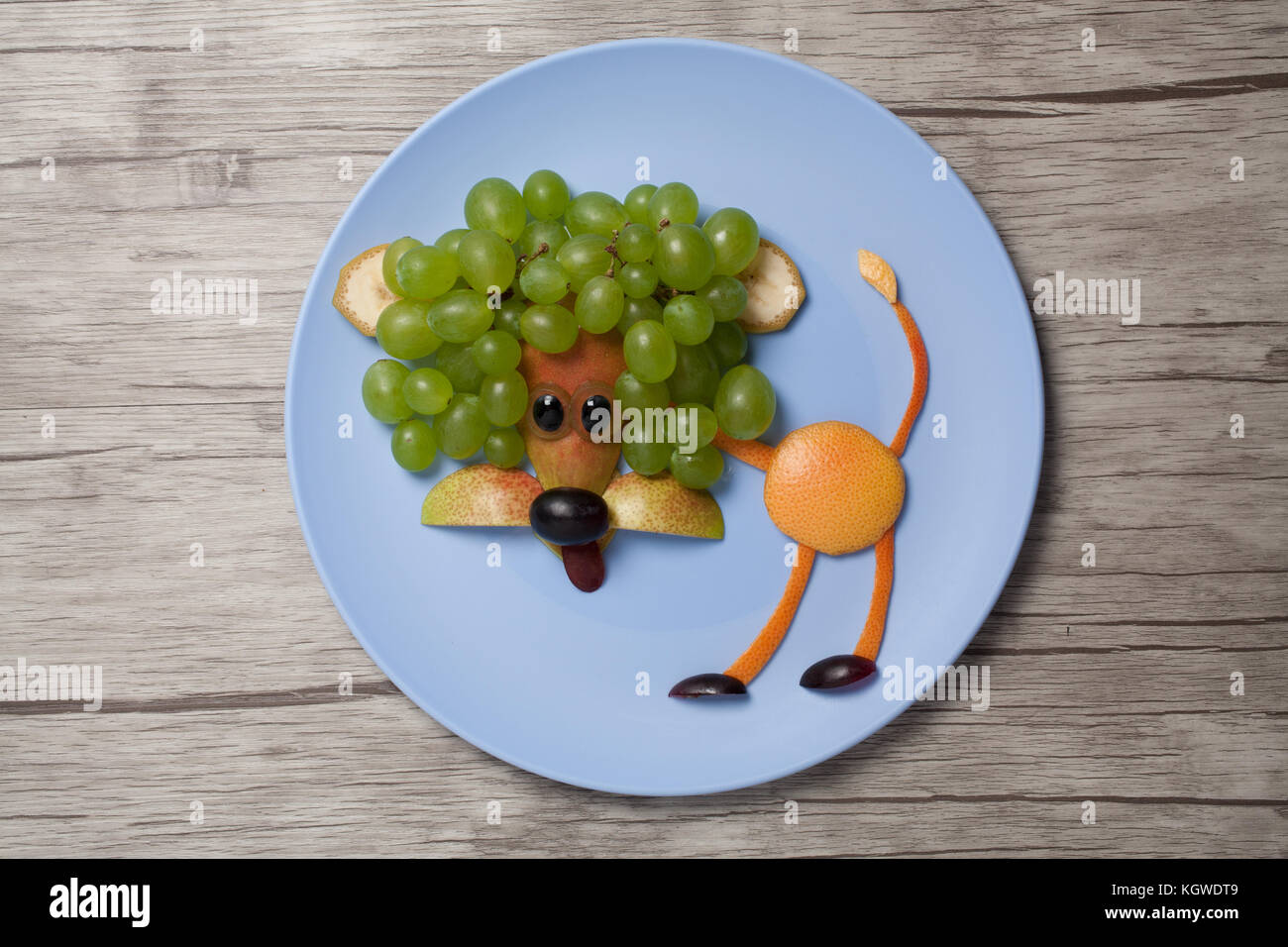 Lion made with fruits on plate and wood Stock Photo - Alamy