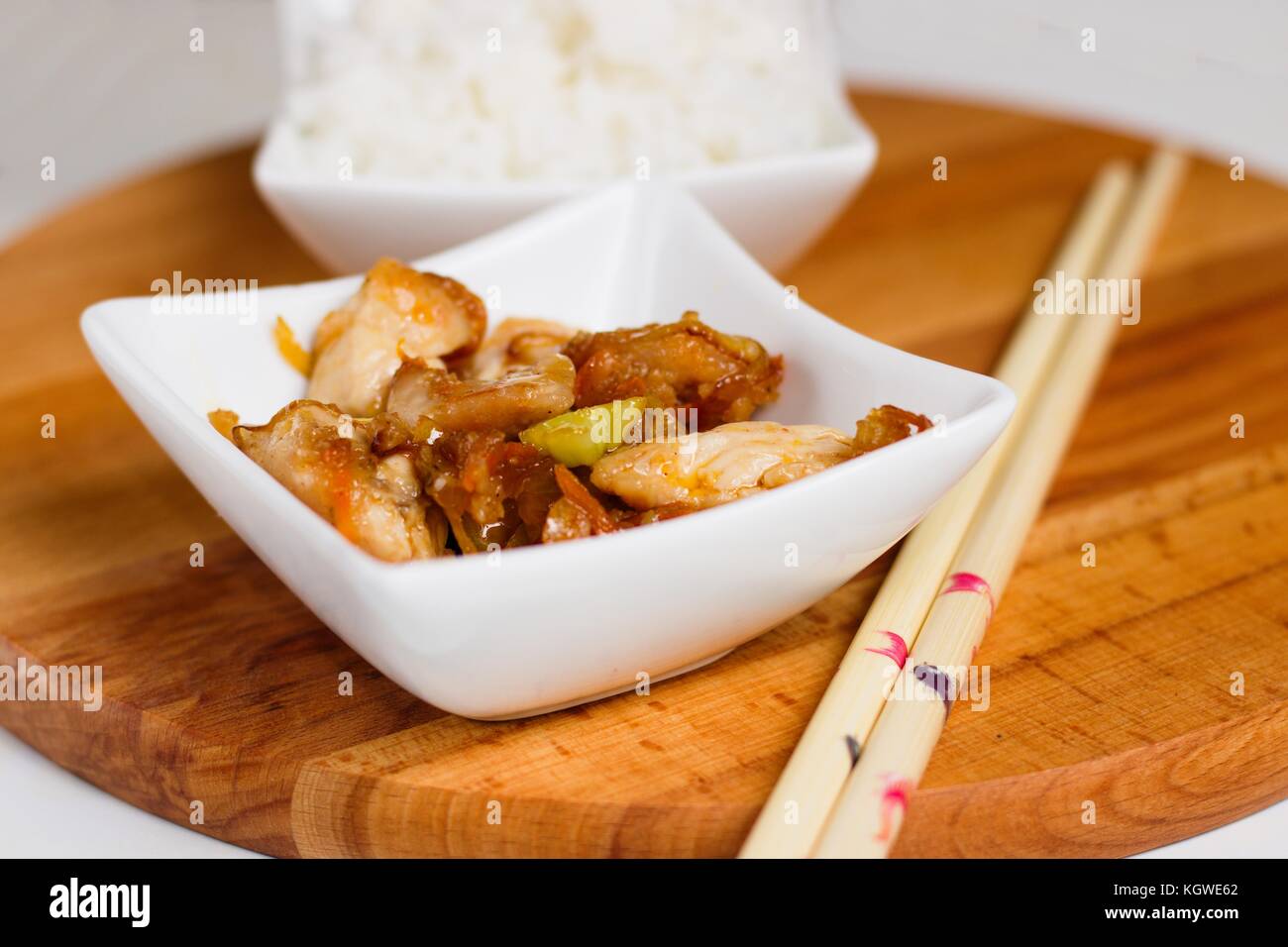 Chinese food served in small white square bowls on wooden board with ...
