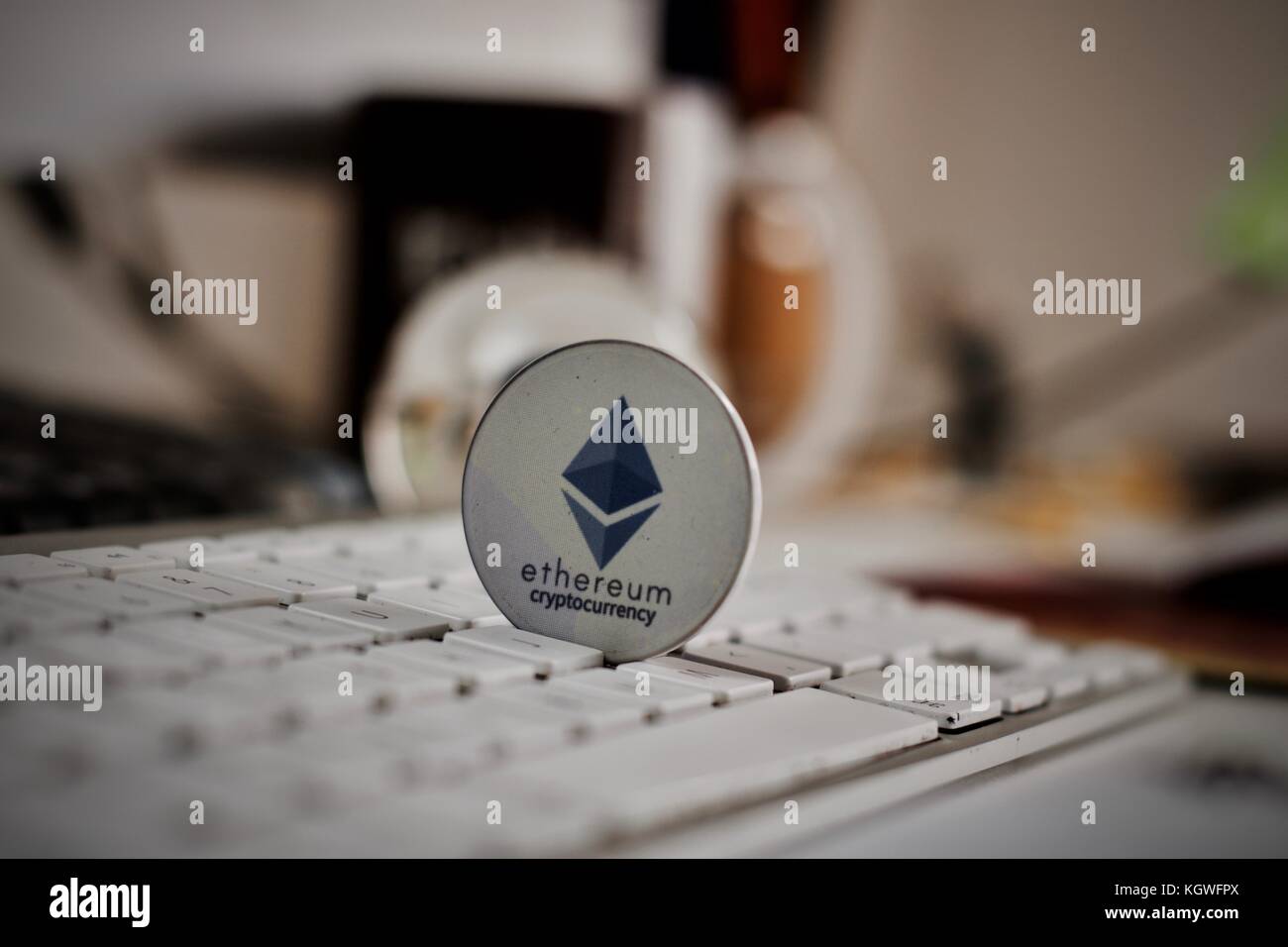 Crypto currency physical grey ethereum token on white keyboard in ...