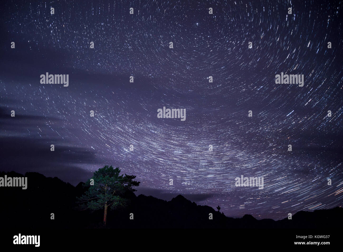 Beautiful night landscape with traces of stars in the night sky and ...