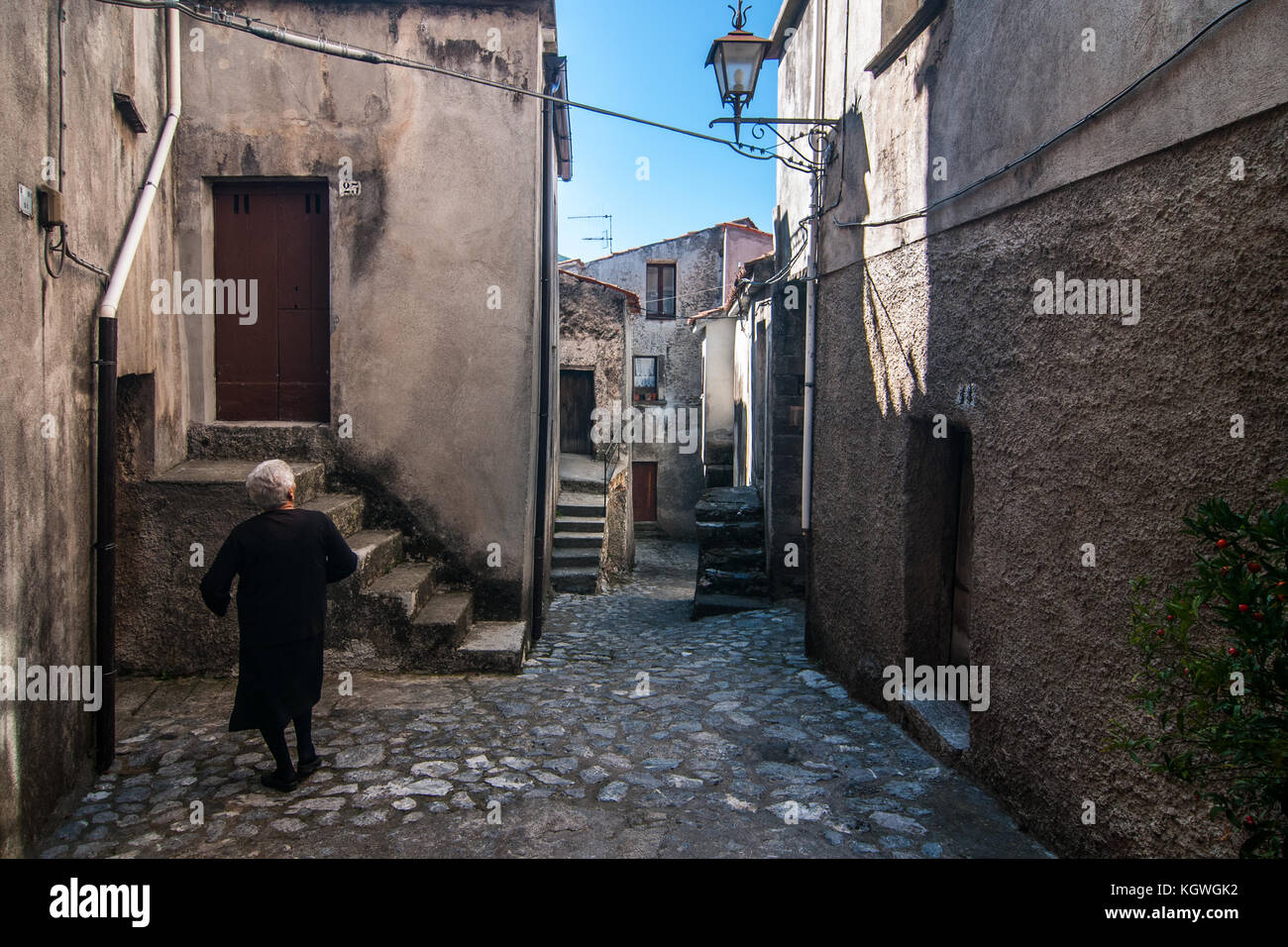 An old woman walks in the streets of the village of Aieta, Italy. Aieta ...