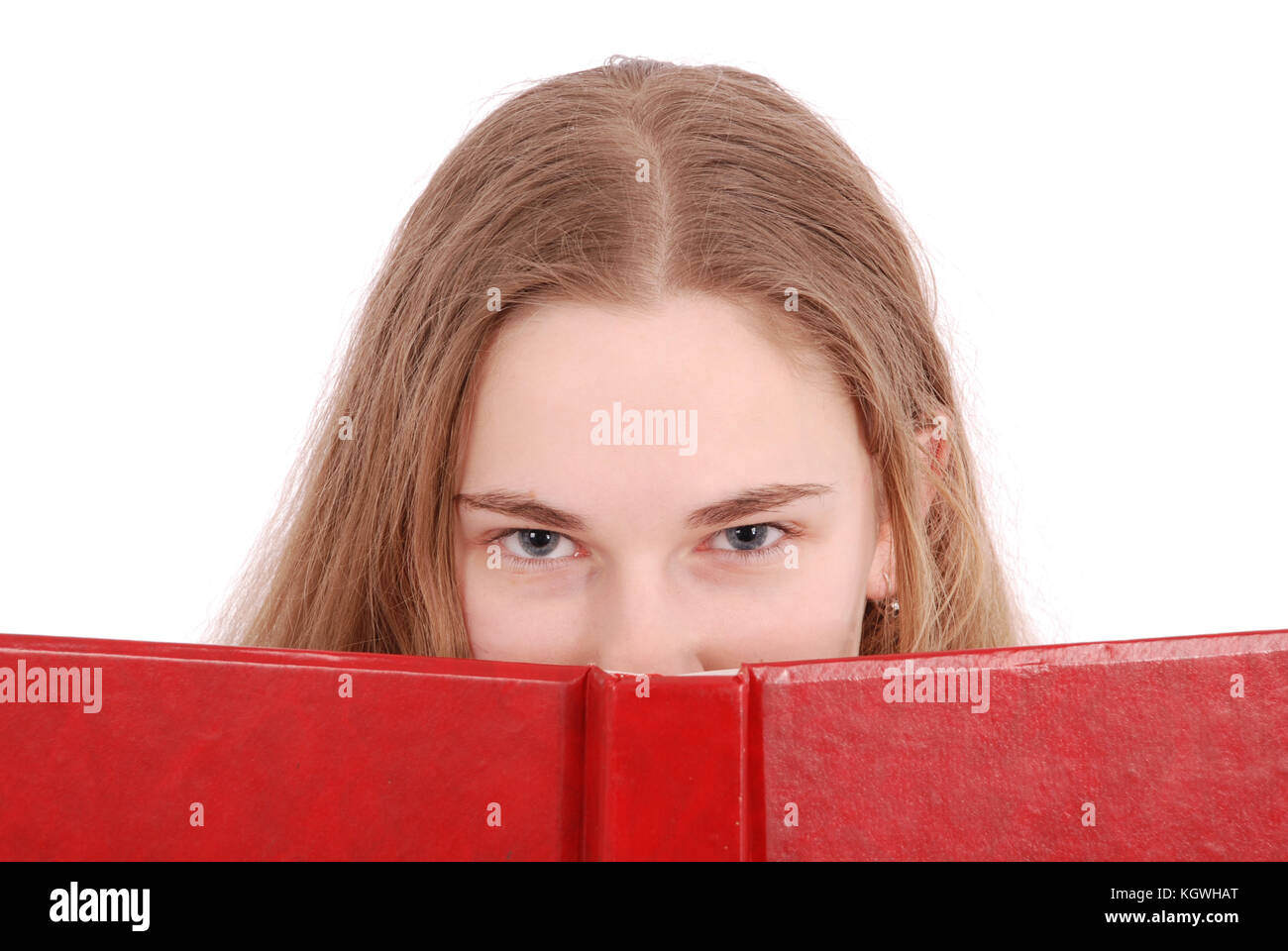 Beautiful school girl peeping from behind her red book isolated on ...