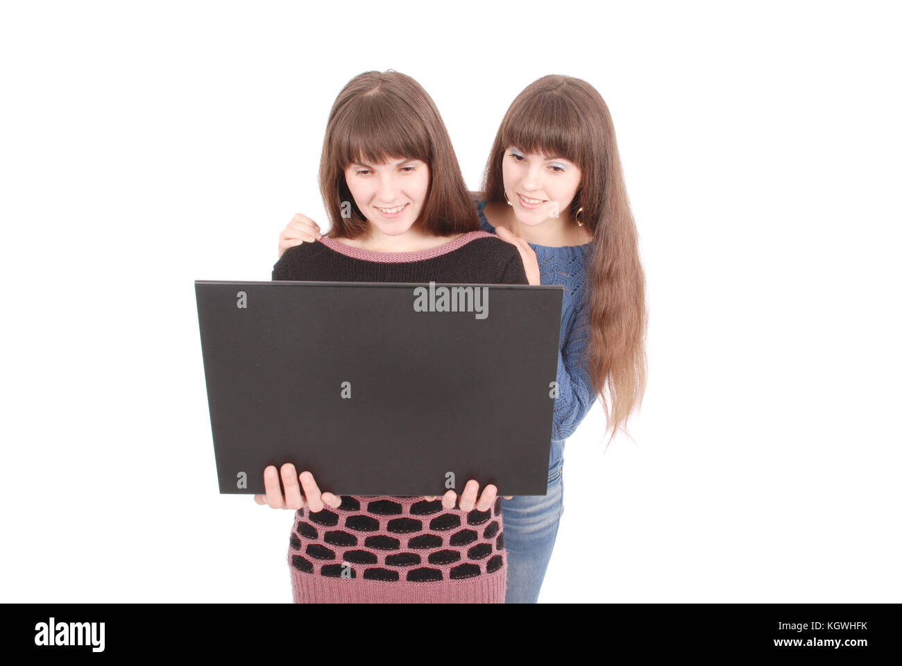 Portrait of two twins sisters with laptop on white background Stock ...