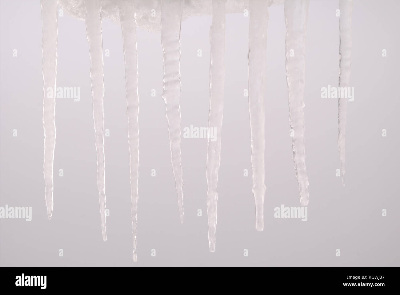Icicles isolated on a grey background. Frozen water Stock Photo - Alamy
