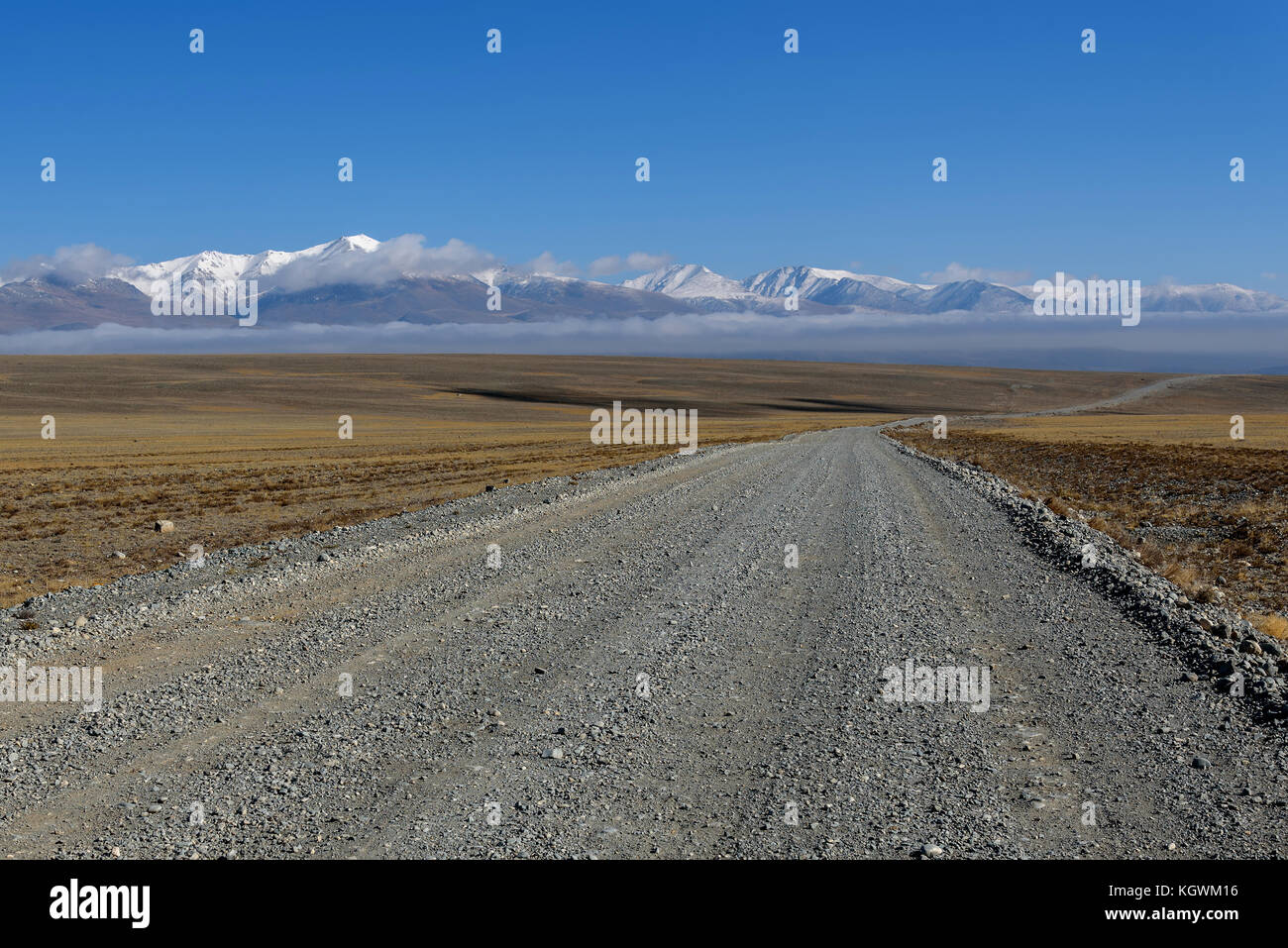 Scenic steppe landscape with a gravel road in the steppe, mountains ...