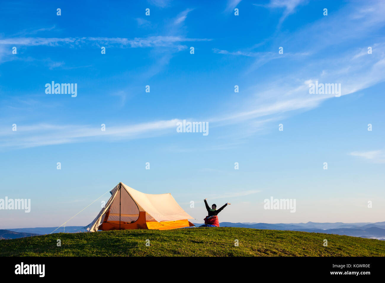 Woman Waking up with the arms up in the air after a night on the top of ...