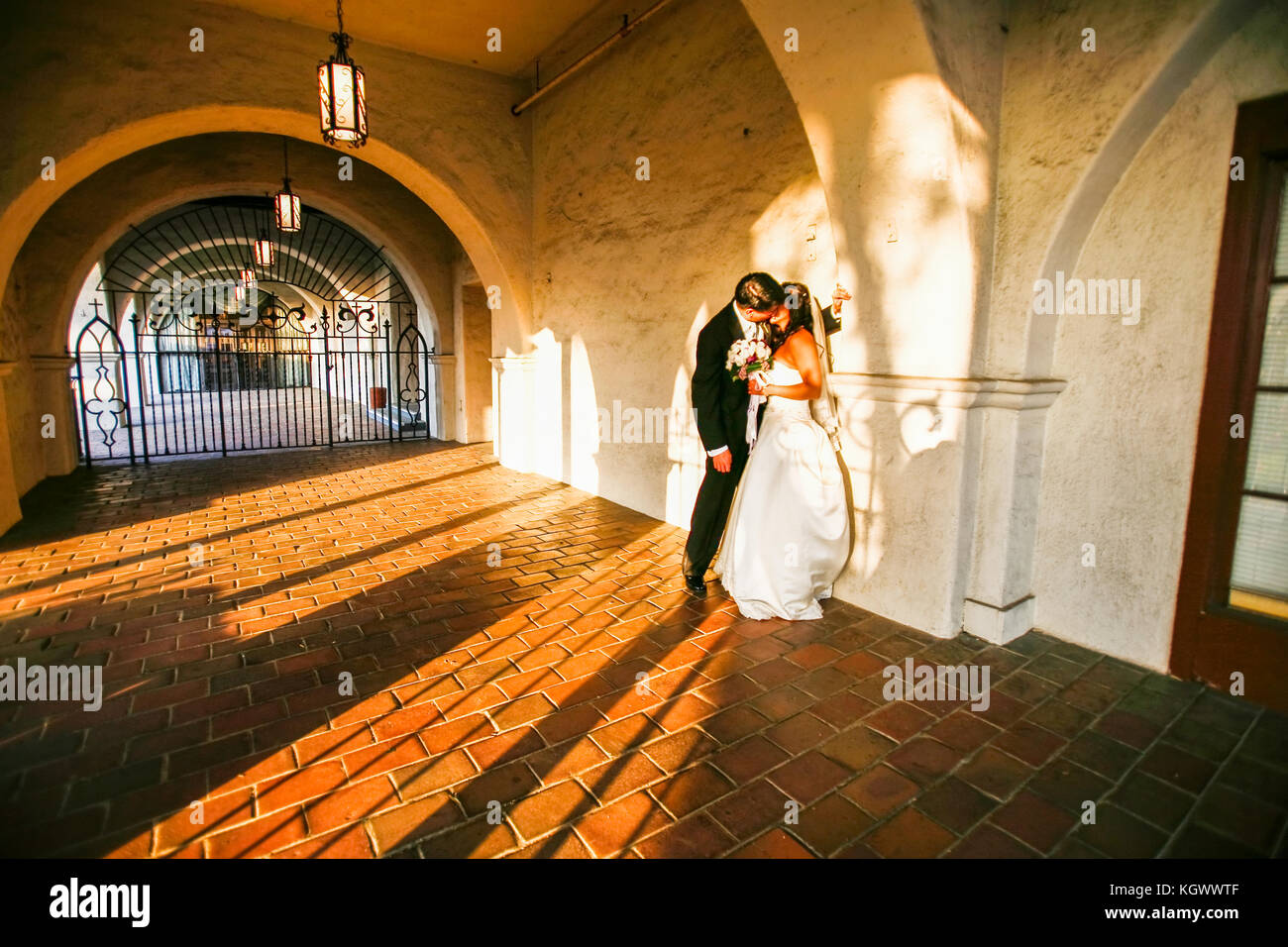 Bride and groom kissing open air hallway hi-res stock photography and ...