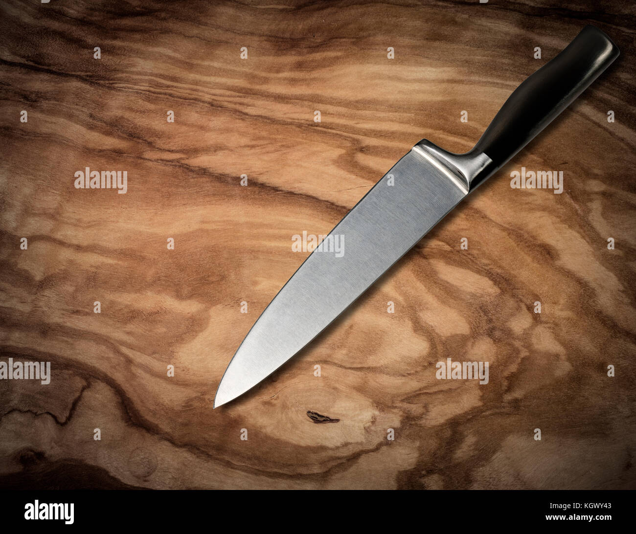 Closeup image of kitchen style chef knife on vintage cutting board ...