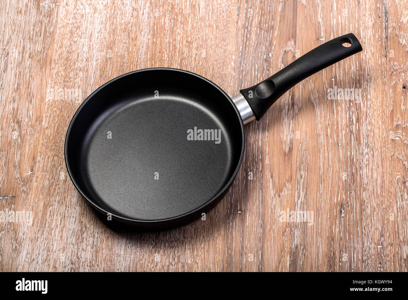 Frying pan on wooden table background Stock Photo - Alamy