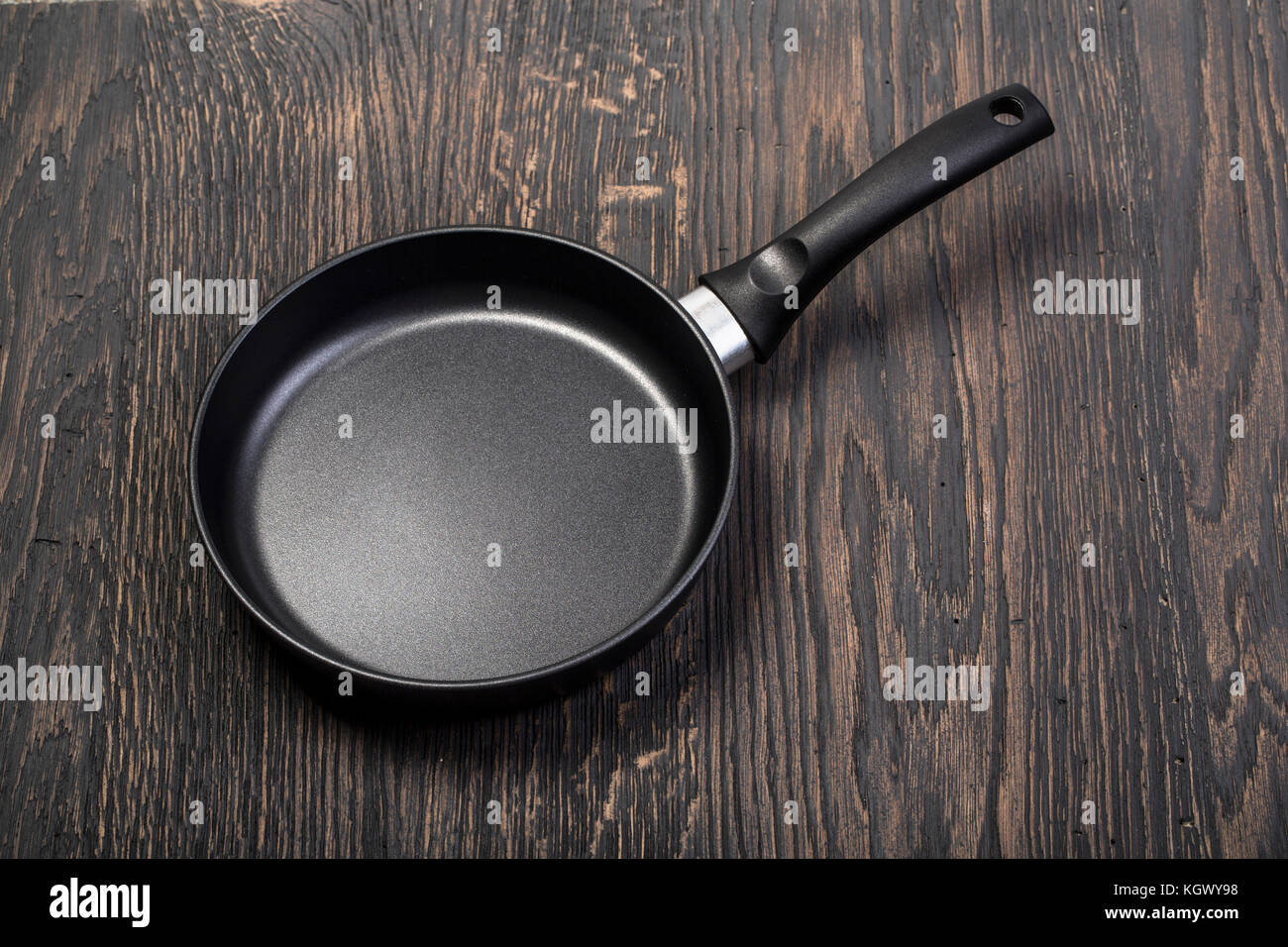 Frying pan on wooden table background Stock Photo - Alamy