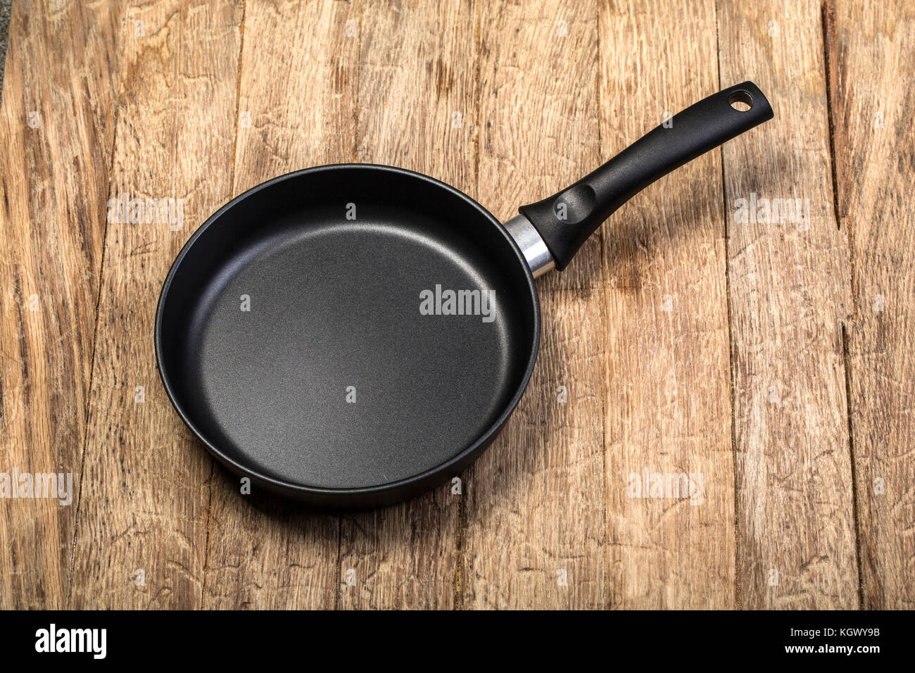 Frying pan on wooden table background Stock Photo - Alamy