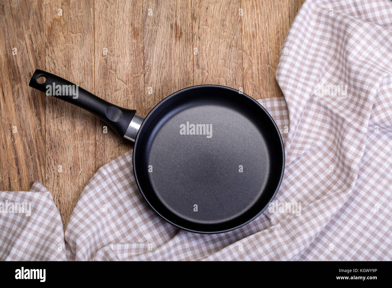 An empty pan on a wooden table and tablecloth background Stock Photo ...