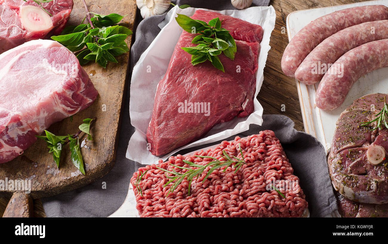 Different types of fresh raw meat on dark wooden background. Top view ...