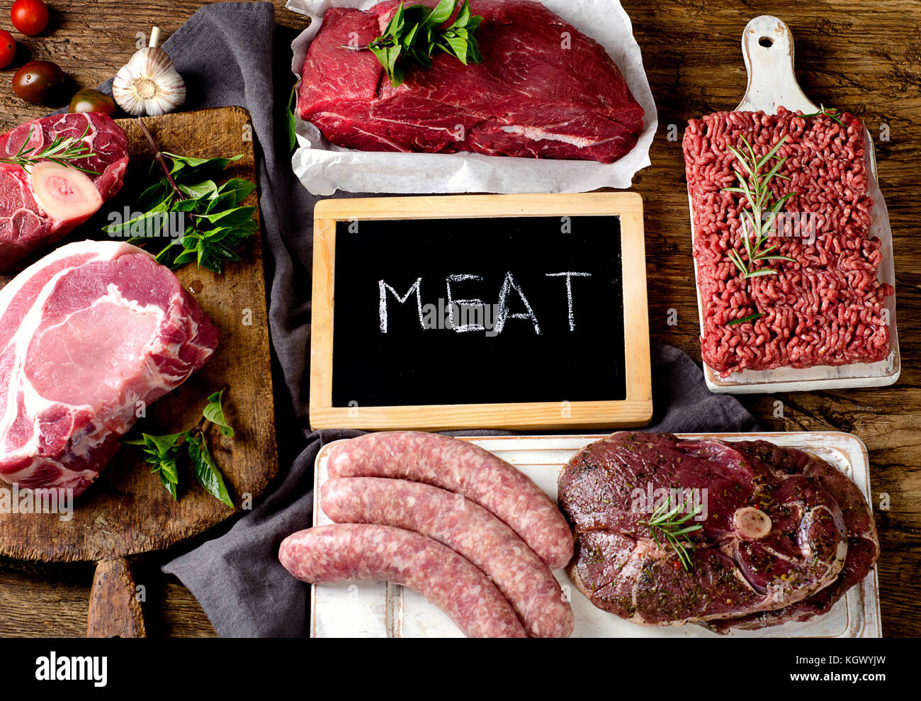 Different types of fresh raw meat on dark wooden background. Top view ...
