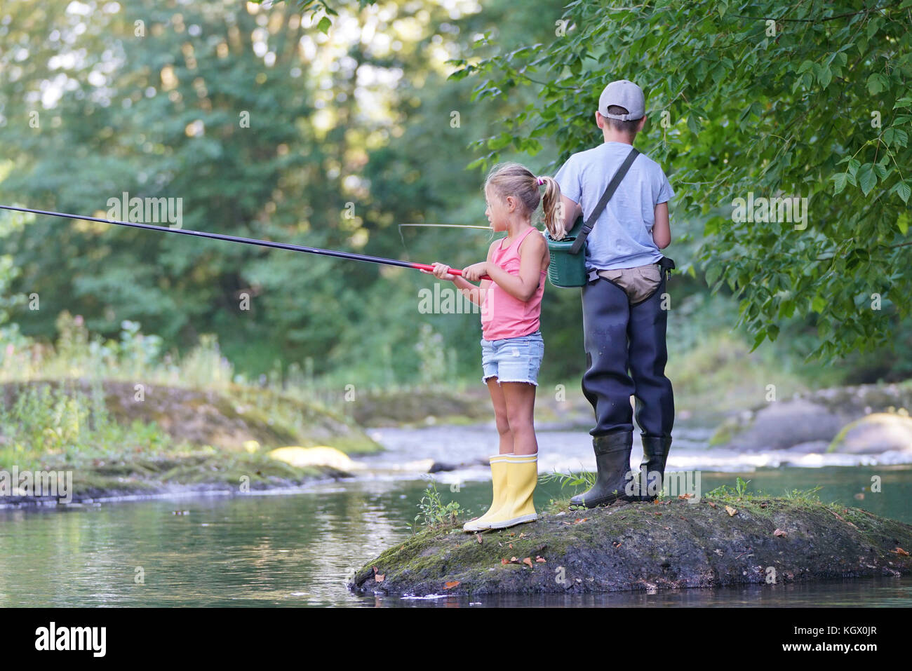 Happy kids fishing in river Stock Photo - Alamy