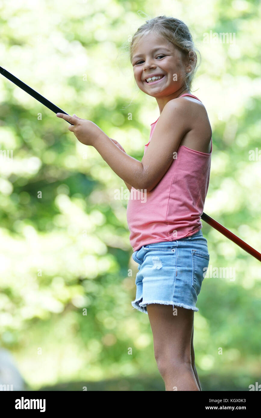 Smiling girl holding fishing line by river Stock Photo - Alamy