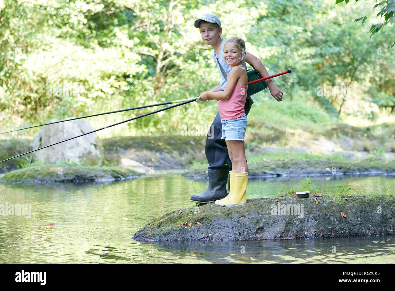 Happy kids fishing in river Stock Photo - Alamy