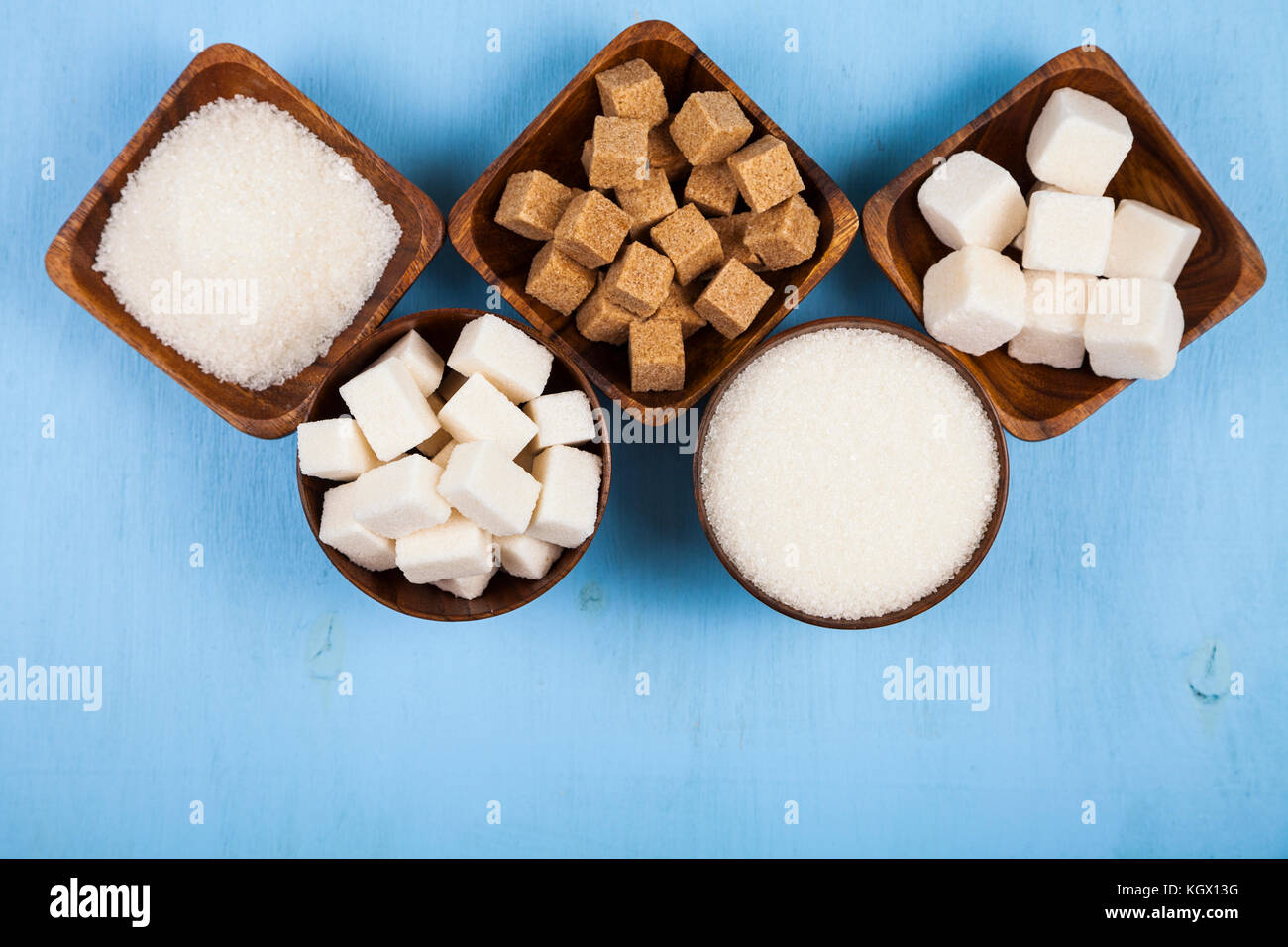 Five bowls of sugar on a blue wooden background, top view Stock Photo ...