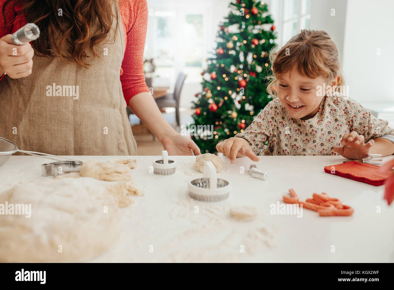 Little girl having fun making cookies. Woman with her daughter making ...