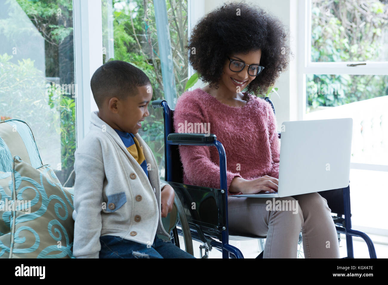 Son and his disabled mother using laptop at home Stock Photo - Alamy