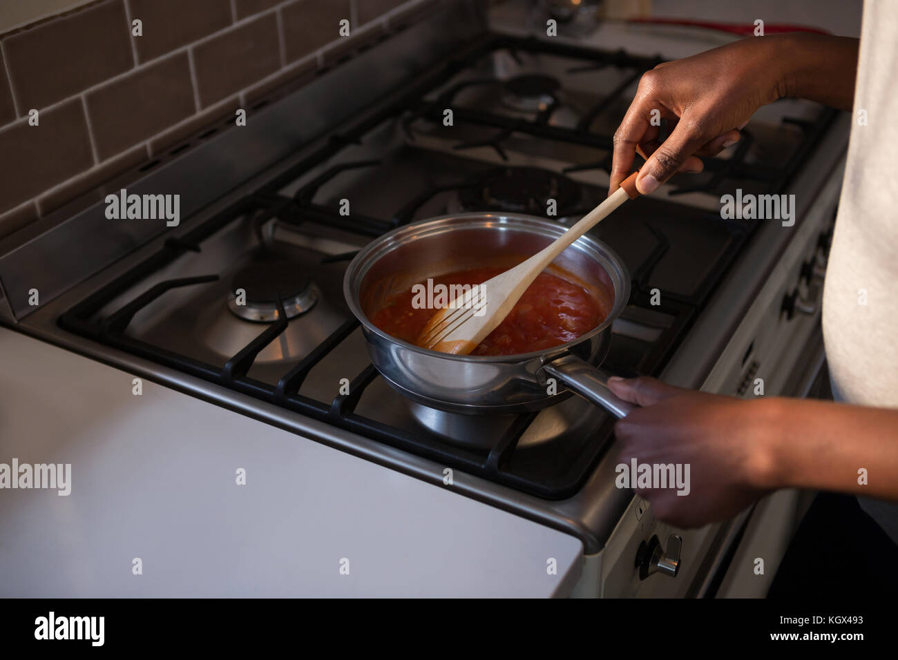 Mid section of woman cooking food in kitchen at home Stock Photo - Alamy