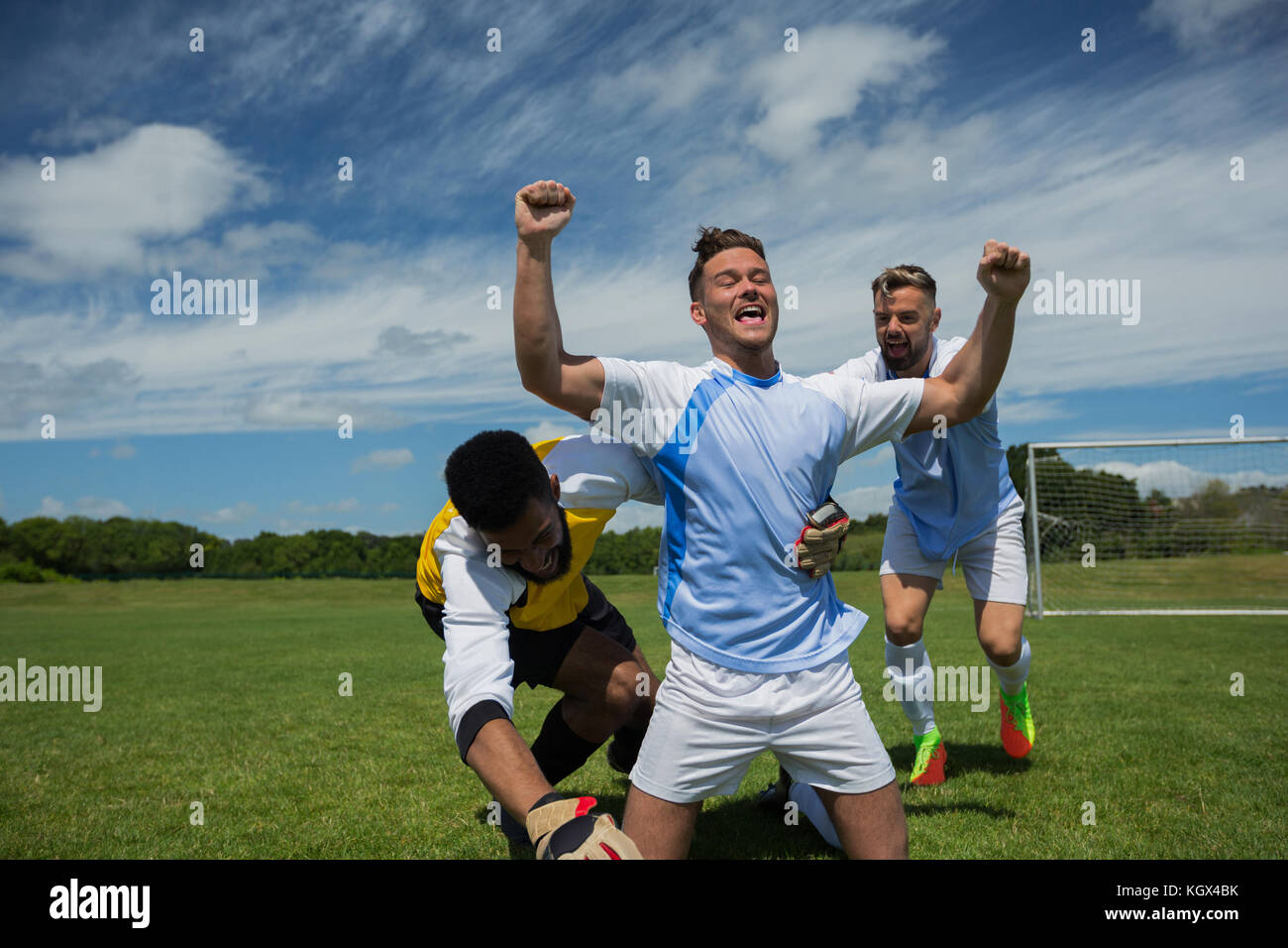 Excited football players celebrating after scoring goal in the ground ...