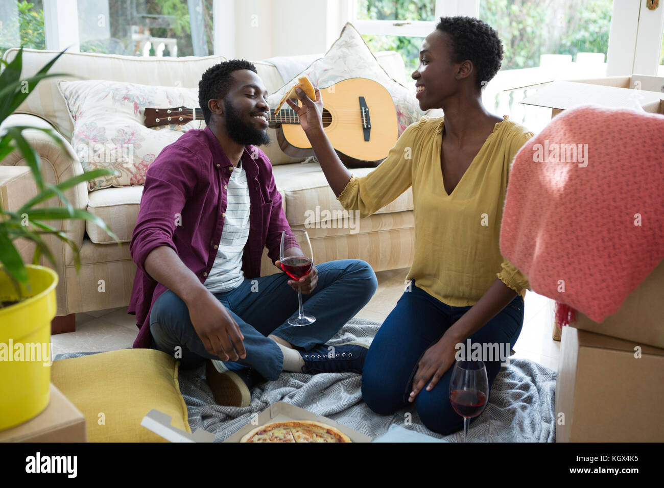 Happy couple having pizza in new house Stock Photo - Alamy