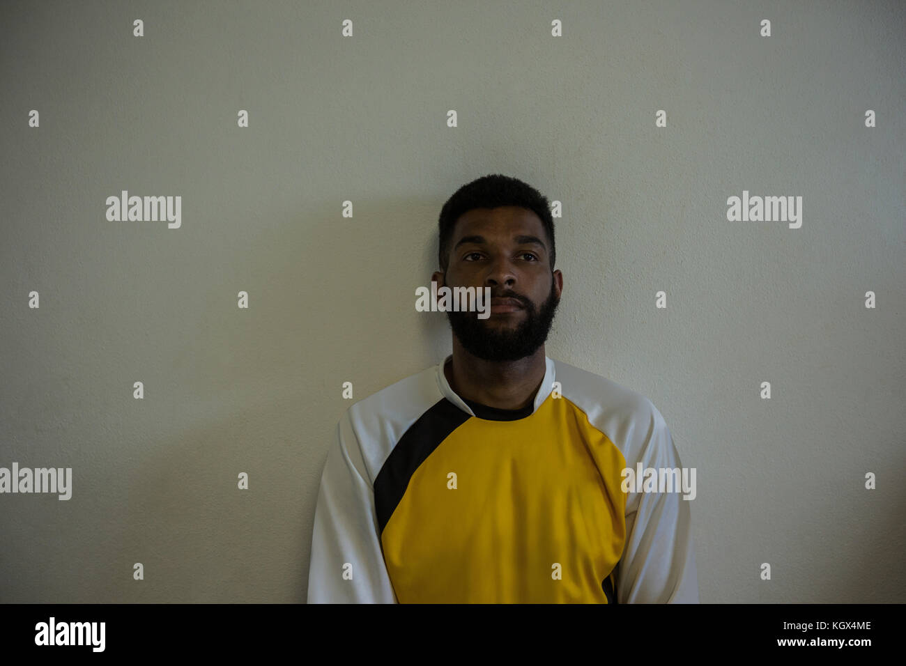 Thoughtful football player relaxing in changing room Stock Photo - Alamy