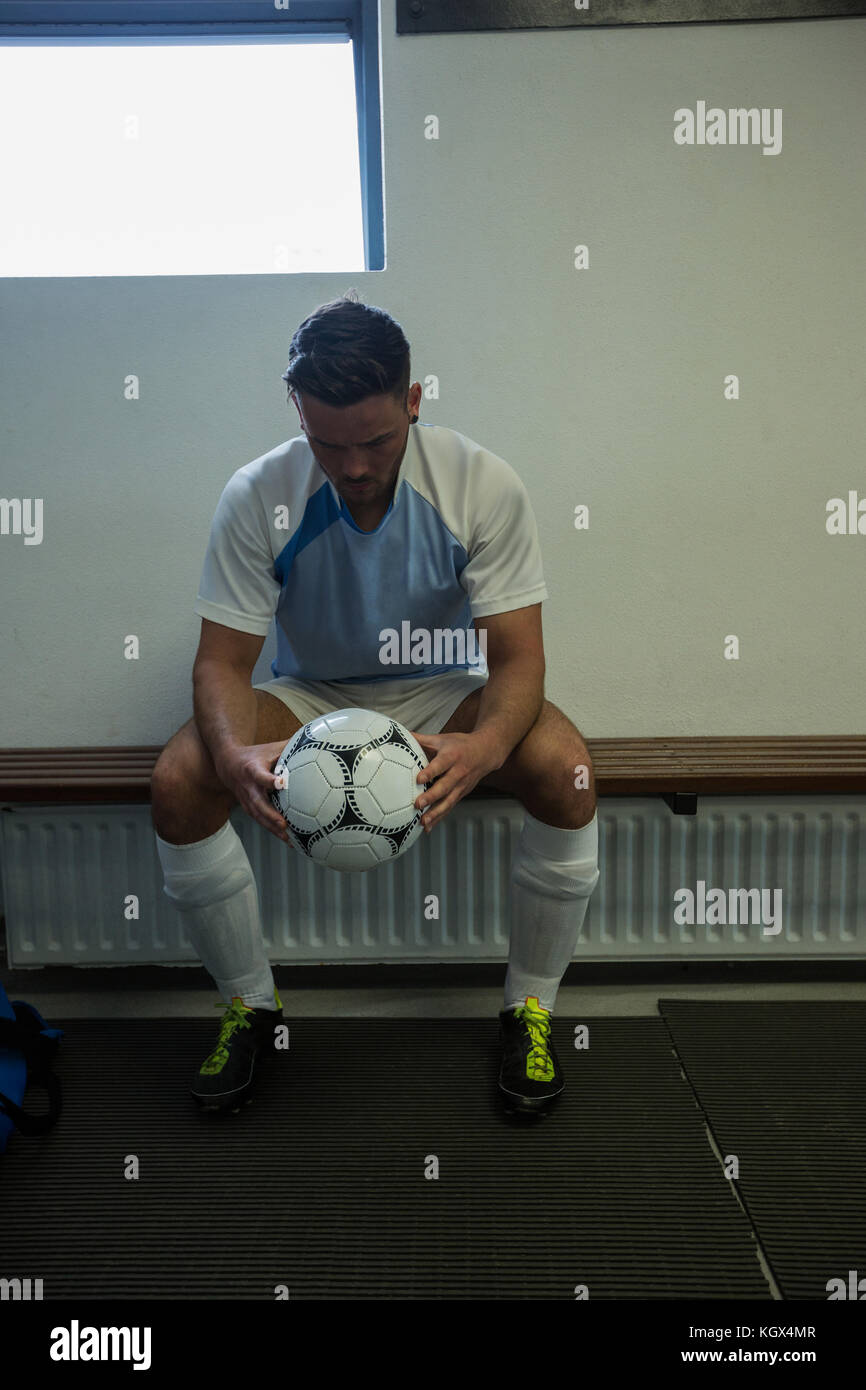 Sad football player sitting on bench in changing room Stock Photo - Alamy