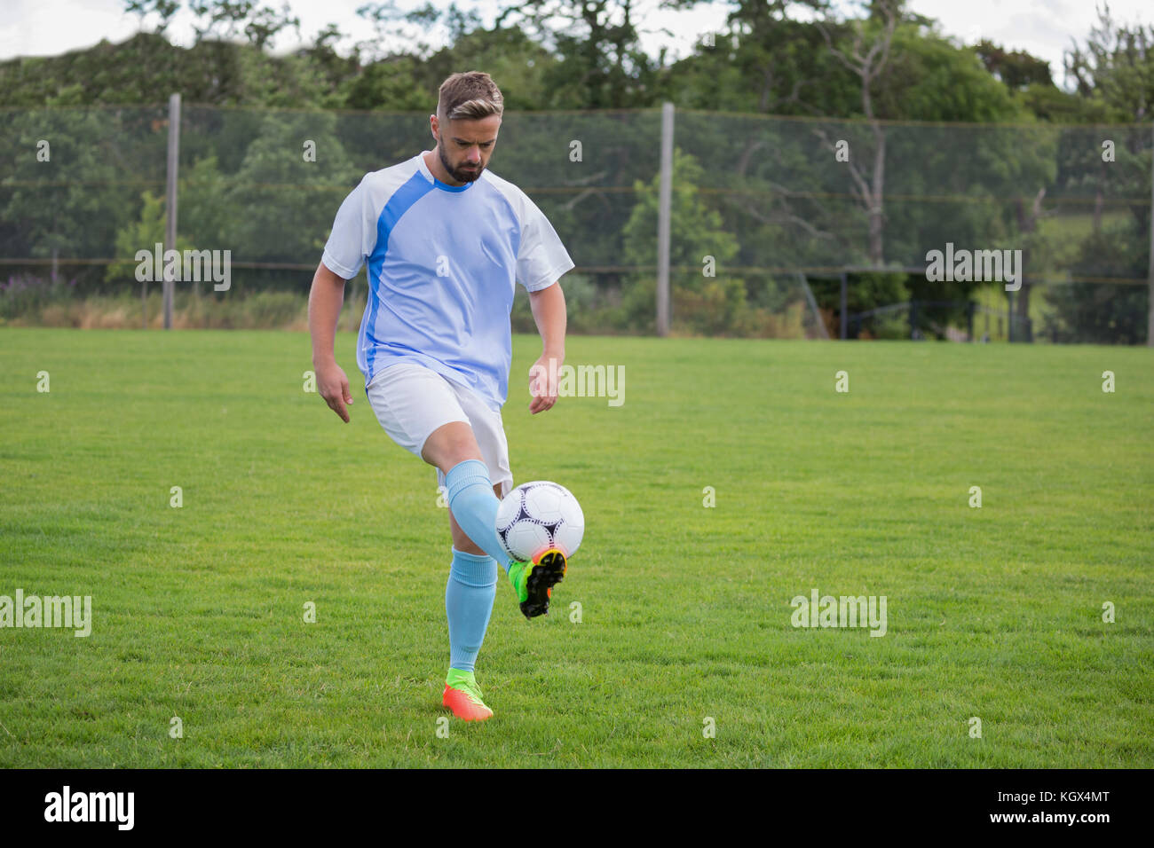 Football player juggling soccer ball in the ground Stock Photo - Alamy